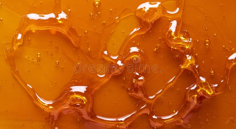 Golden Liquid with a Viscous Texture Spread Across a Surface Generated ...