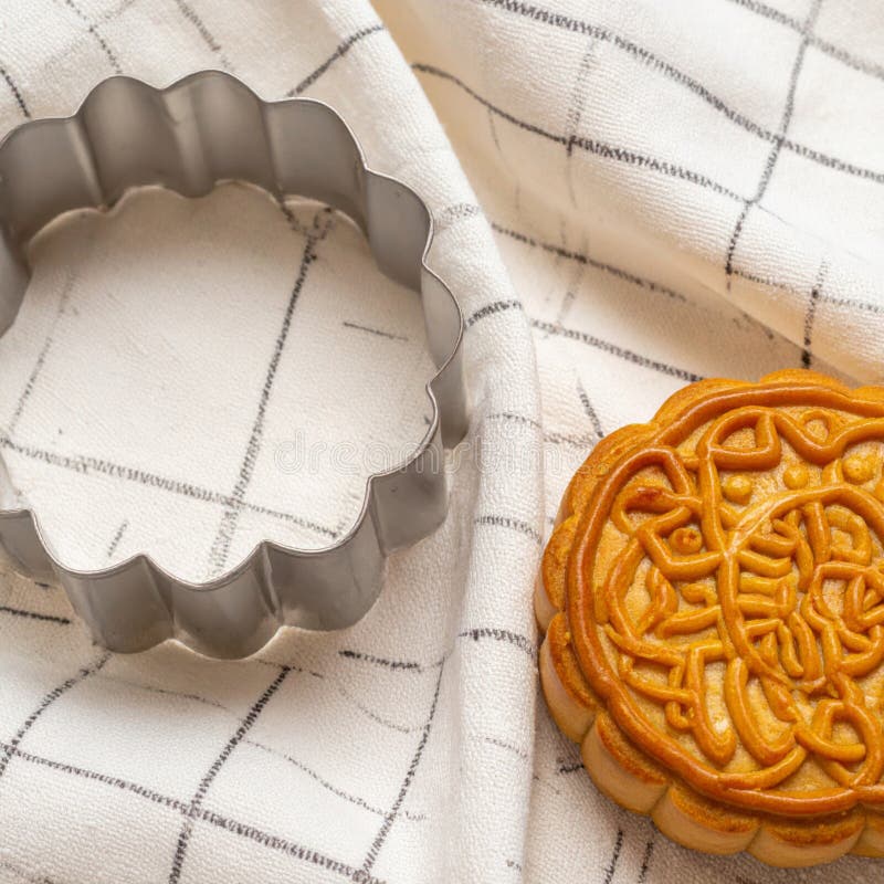 Golden Mooncake with Metal Cookie Cutter on Patterned Cloth Background ...