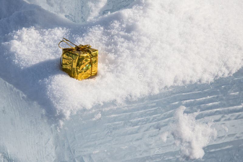 Golden parcel in snow stock photo. Image of christmas - 68615276