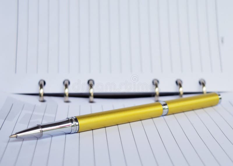 Golden Pen on note pad stock photo. Image of arrange - 93844254