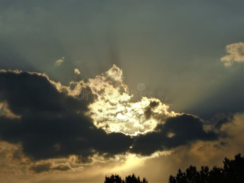 Golden Rays Piercing through the Clouds: a Dramatic Sunset Stock Photo ...