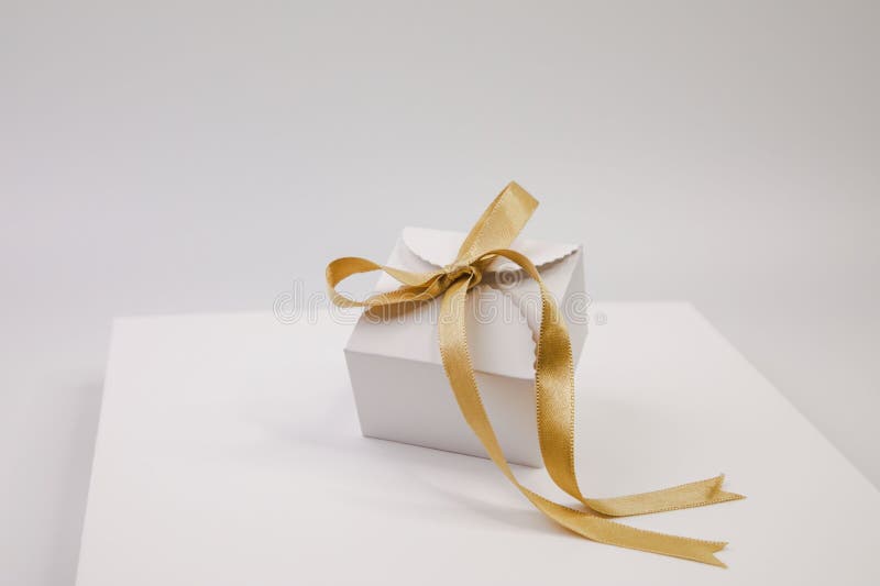 Golden Ribbon with a Bow on a Rectangular Box, Illuminated by Soft ...
