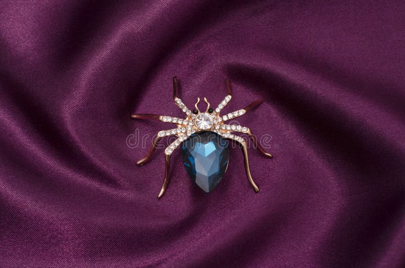 Golden Spider with a Big Blue Stone on Silk Fabric Stock Photo - Image ...