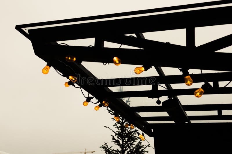 Golden String Lights Under a Dark Silhouette Structure Create a Cozy ...