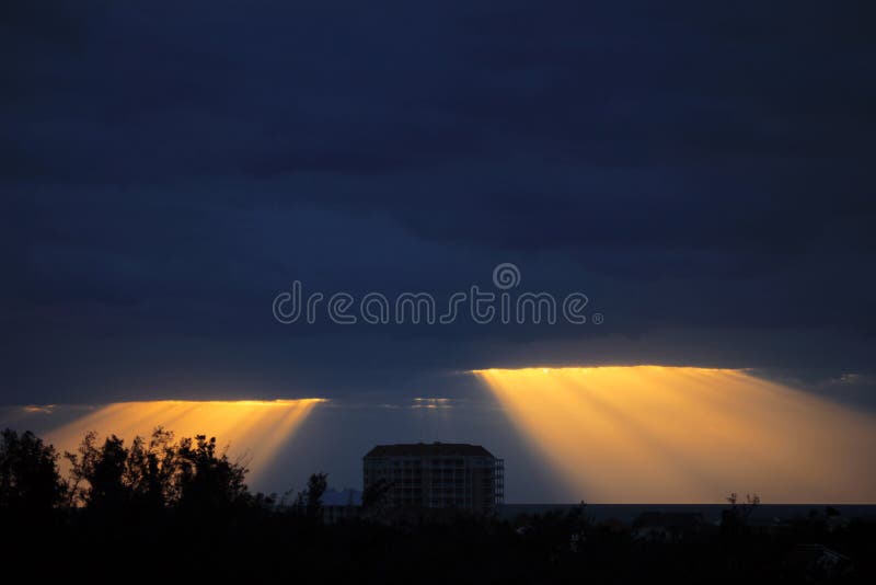 Golden Sun Rays Bursting through the Dark Blue Clouds Stock Photo ...