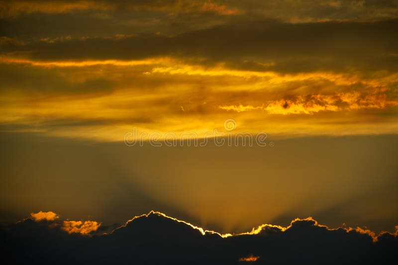Golden Sunset Over Dark Clouds with Radiant Sun Rays Stock Photo ...