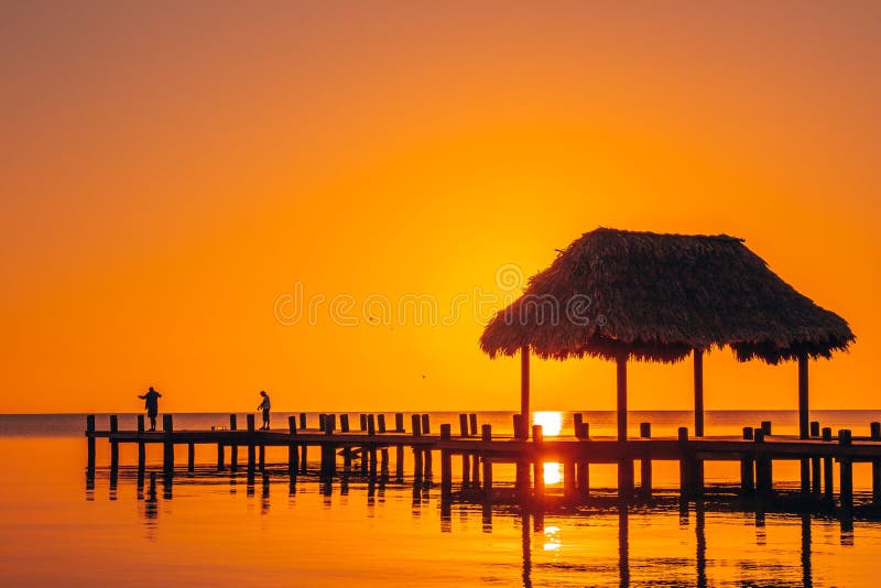 Golden Sunset Over the Ocean with the Silhouette of a Beach Umbrella in ...