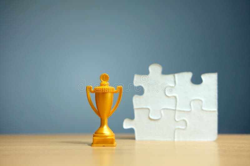 Golden Trophy with White Puzzle on a Wooden Table Stock Image - Image ...