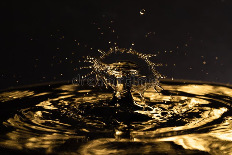 Golden Water Splash Isolated on a Black Background. Stock Photo - Image ...