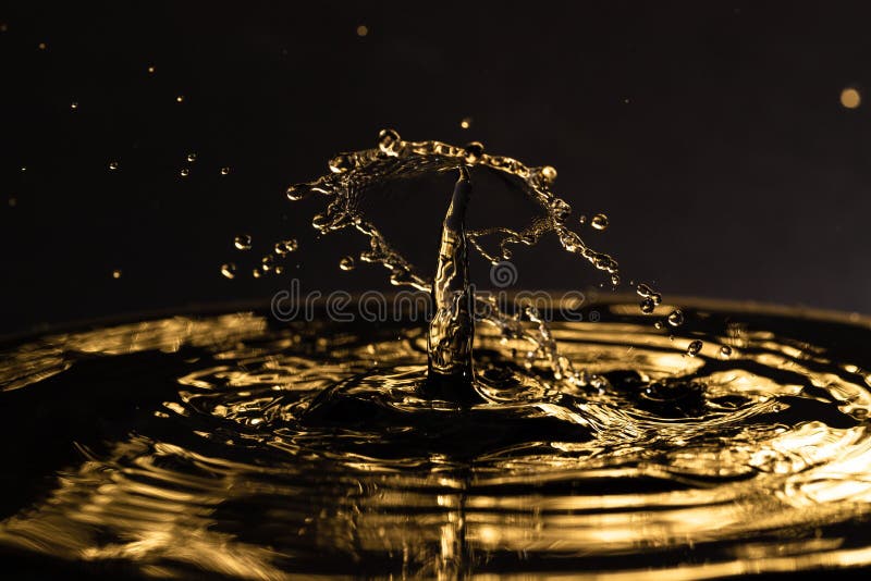 Golden Water Splash Isolated on a Black Background. Stock Photo - Image ...