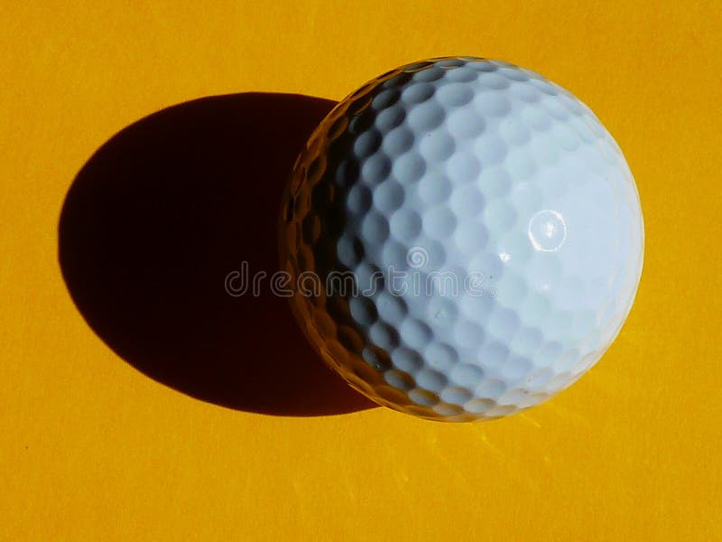 Golf Ball Close Up on Yellow Background with Strong Shadow Stock Image ...
