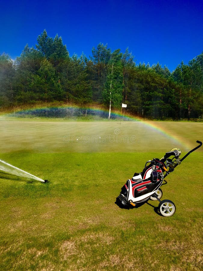 Golf Cart on a Green Course with a Rainbow in the Background Stock ...