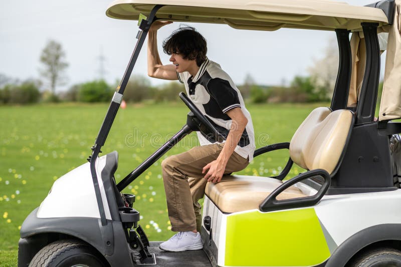 Dark-haired Guy Sitting in a Vehicle on a Golf Field Stock Image ...
