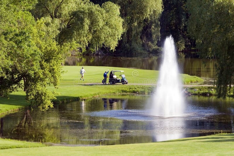 Golf Course Fountain and Golfers Stock Image - Image of fairway, autumn ...
