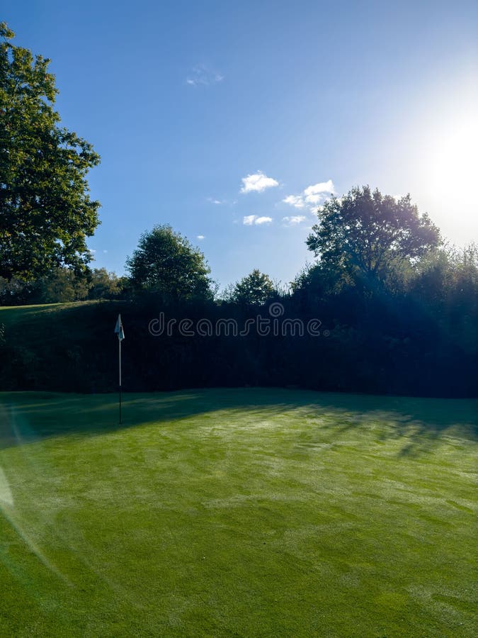 Golf Course Green with Blue Sky and Flag in View, Autumn Day with Dew ...