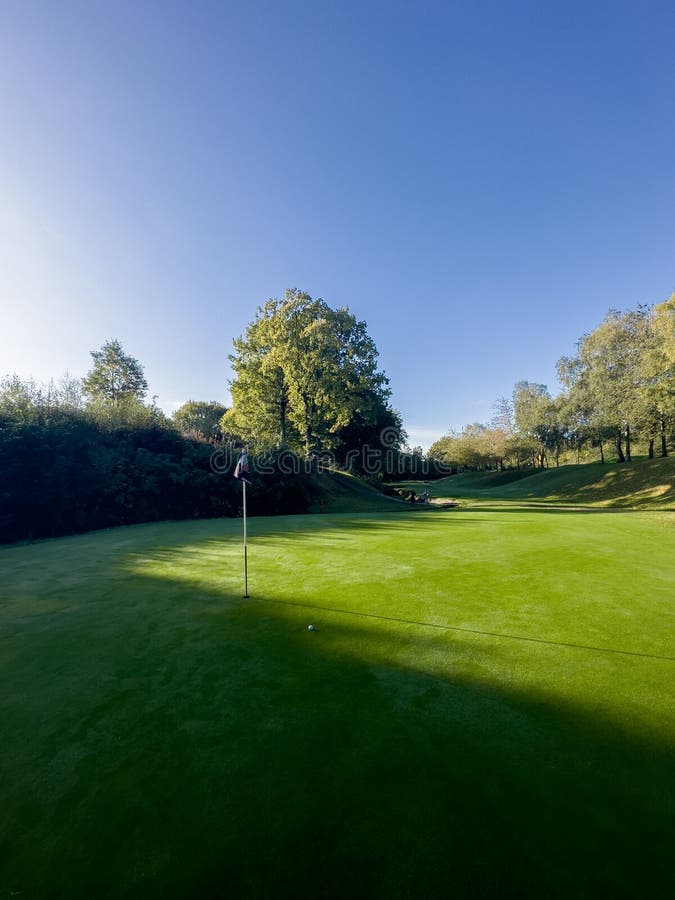 Golf Course Green with Blue Sky and Flag in View, Autumn Day with Dew ...