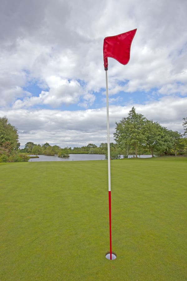 Golf Green with Red Golf Flag Stock Photo - Image of luxury, clouds ...