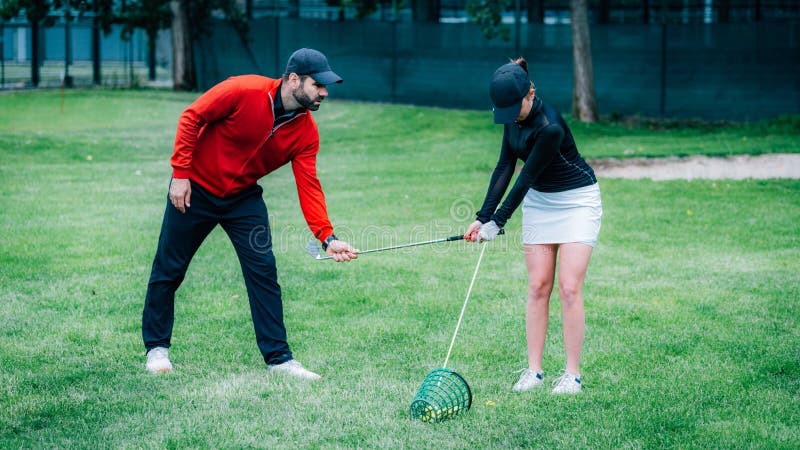 Golf Instructor Working with Young Woman on Swing Improvement Stock ...