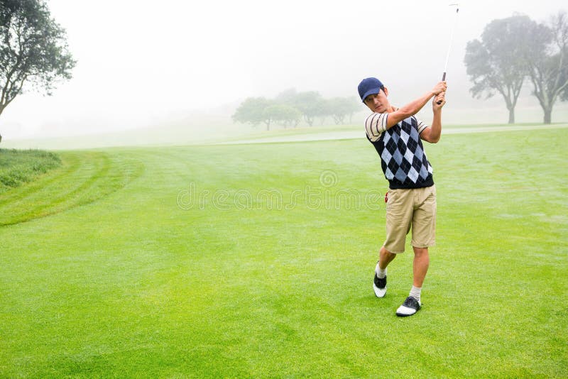Golfer teeing off stock image. Image of clothing, swing - 50486275