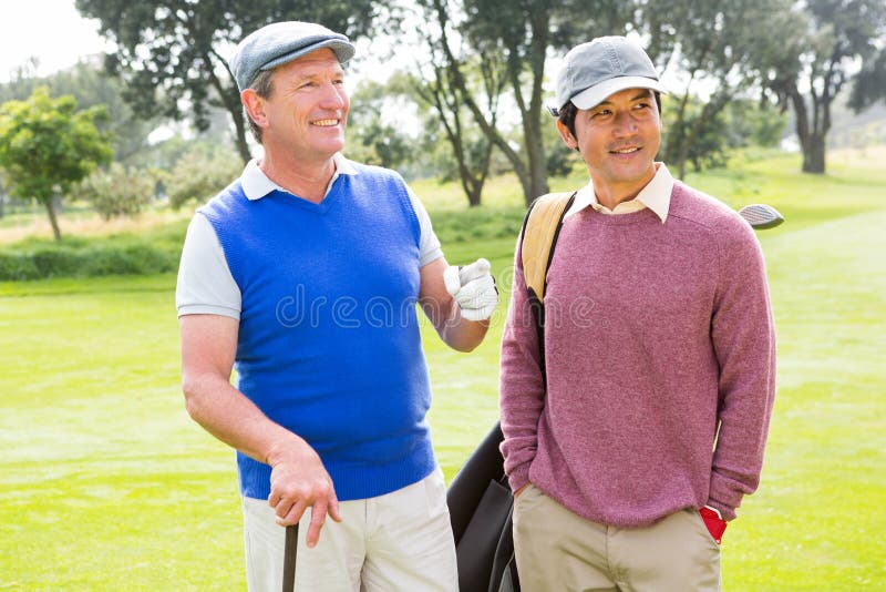 Golfing Friends Smiling and Holding Clubs Stock Image - Image of ...
