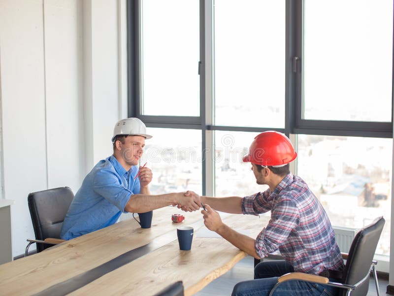 Good Looking Construction Workers are Shaking Hands while Working in ...