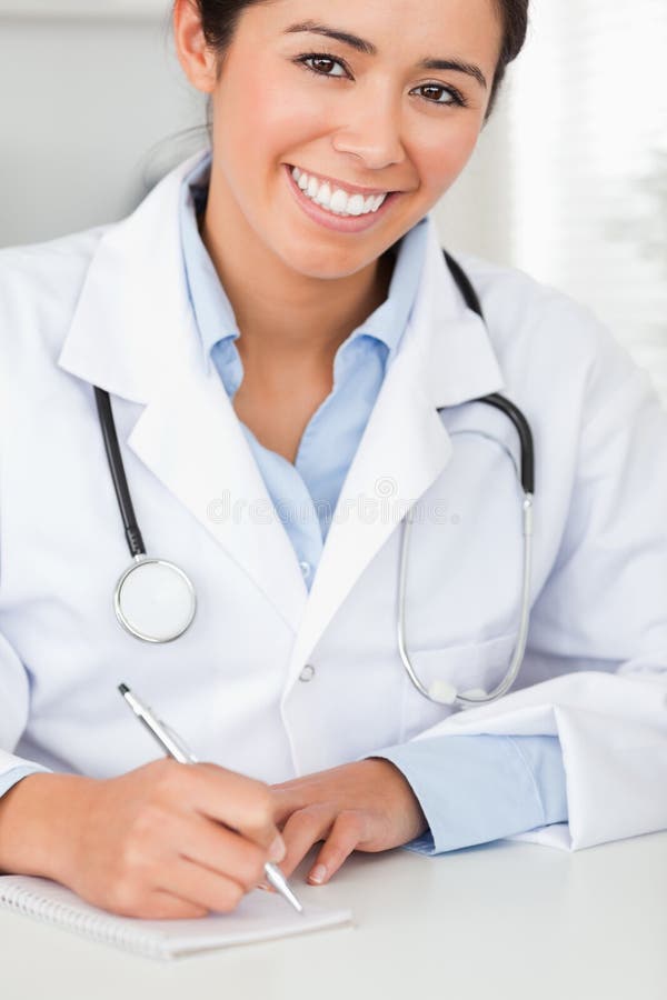 Good Looking Female Doctor Writing on a Scratchpad Stock Photo - Image ...