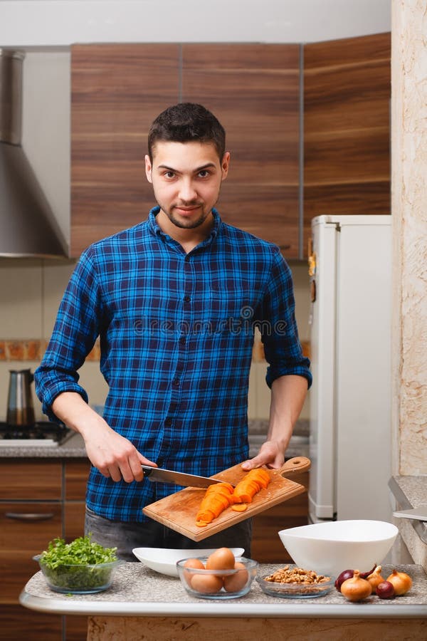 Good Looking Man in an Apron Cutting Some Vegetables To Make Him Stock ...