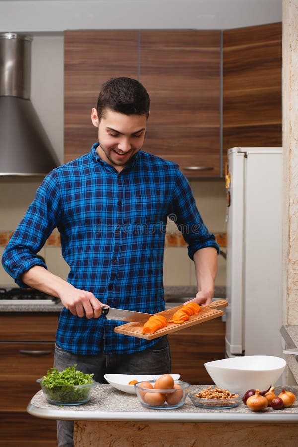 Good Looking Man in an Apron Cutting Some Vegetables To Make Him Stock ...