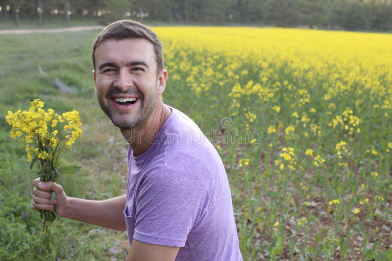 Good Looking Man Gathering Wild Flowers and Smiling Stock Photo - Image ...