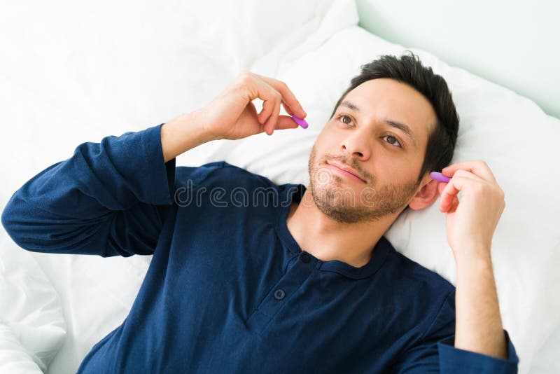 Good-looking Man Using Ear Plugs To Fall Asleep Stock Photo - Image of ...