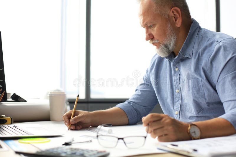 Good Looking Mature Architect Drawing Something while Working in the ...