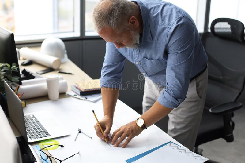 Good Looking Mature Architect Drawing Something while Working in the ...