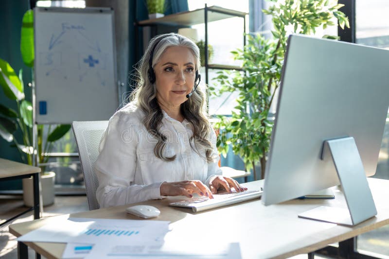 Good-looking Mature Business Woman at the Computrer Looking Busy Stock ...