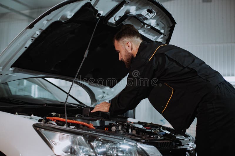 Good Looking Mechanic Guy Working on the Engine of the Car he Solve the ...