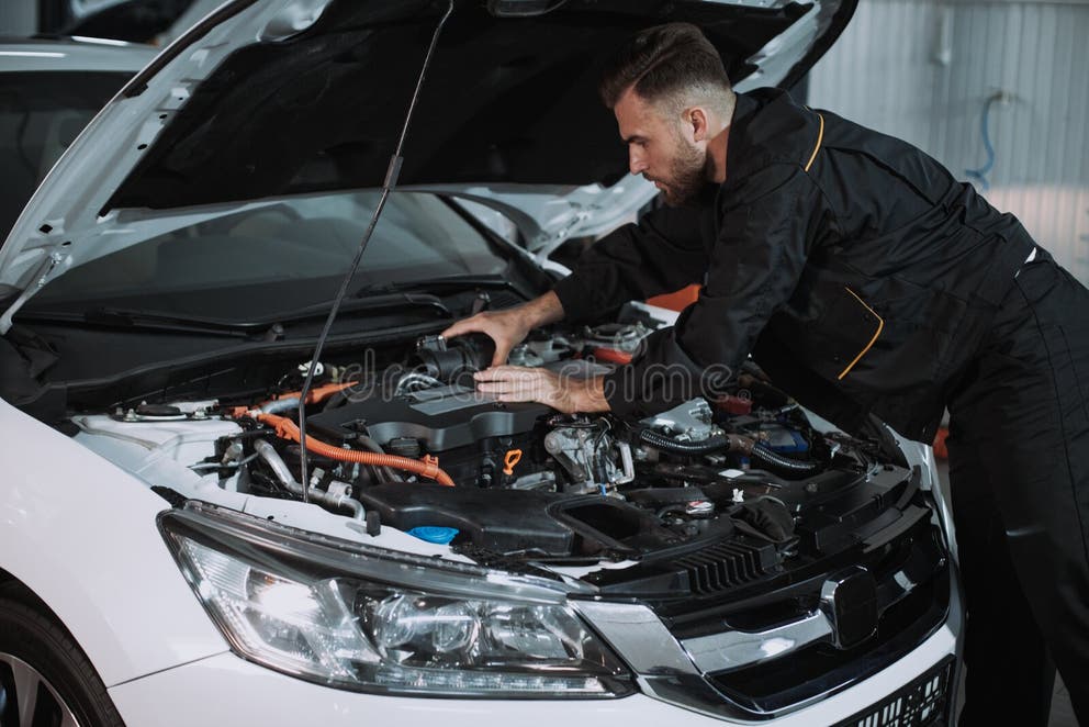 Good Looking Mechanic Guy Working on the Engine of the Car he Solve the ...