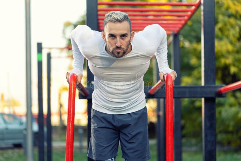 Good Looking Muscular Man Focused on His Exercise while Doing Dips on ...