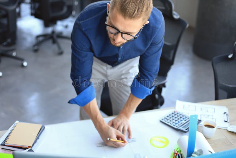 Good Looking Young Man Drawing Something while Working in the Office ...