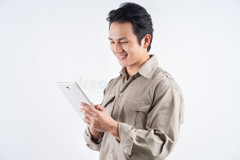 Good Looking Young Mechanic in Overalls Using a Tablet Computer for ...
