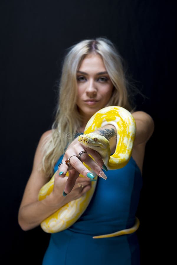 A Lovely Blonde Model Poses with a Boa Snake in a Studio Environment ...