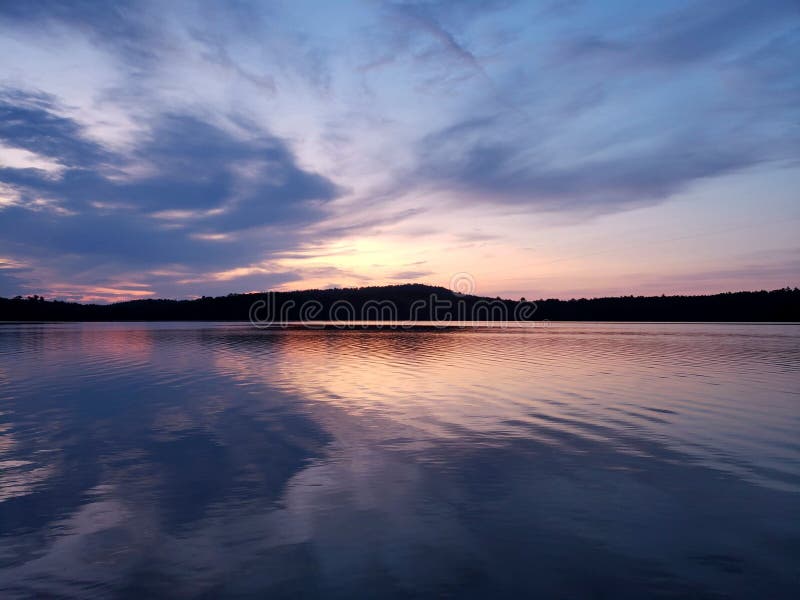 The Sunset Reflecting Off the Calm Water of a Lake As Seen from Behind ...