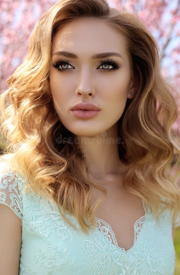 Gorgeous Woman With Blond Hair In Elegant Dress Posing In Blosso Stock