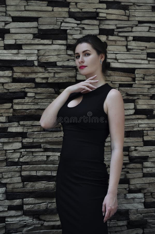 Strict and Gorgeous Woman in Black Dress is Standing Near the Brick ...