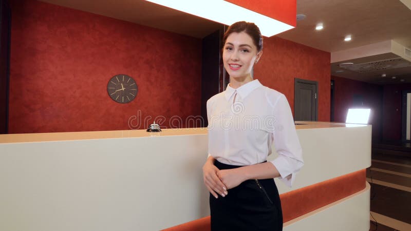 Graceful Female Receptionist is Standing in Hotel Lobby and Smiling ...