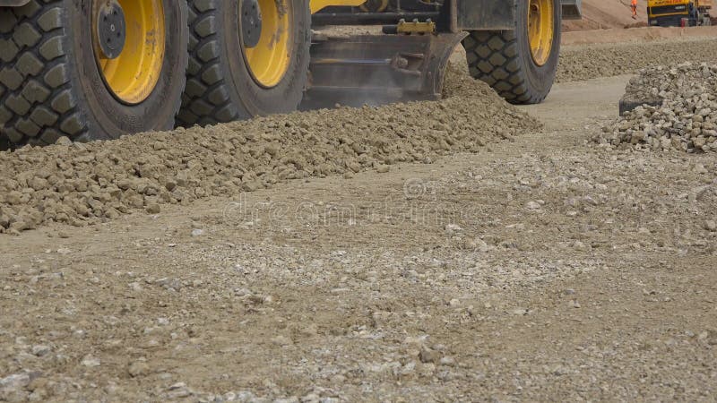 Grader Machine Leveling Rubble Stones on New Road Construction Stock ...