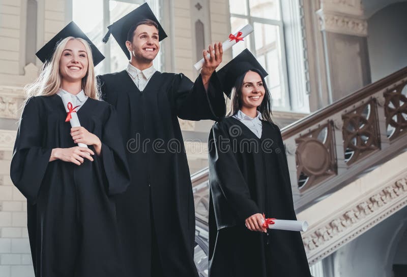 Graduados en universidad foto de archivo. Imagen de disfrutar - 98007836