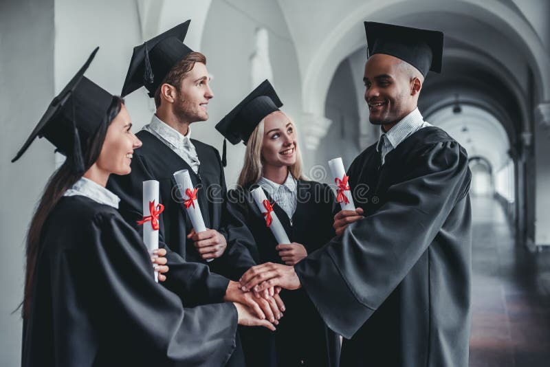Graduados en universidad imagen de archivo. Imagen de casquillo - 98008109