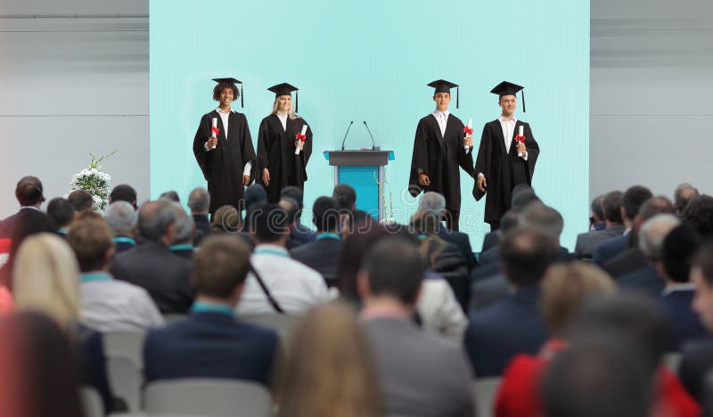 Graduate Students Holding Certificates Standing on a Podium in Front of ...