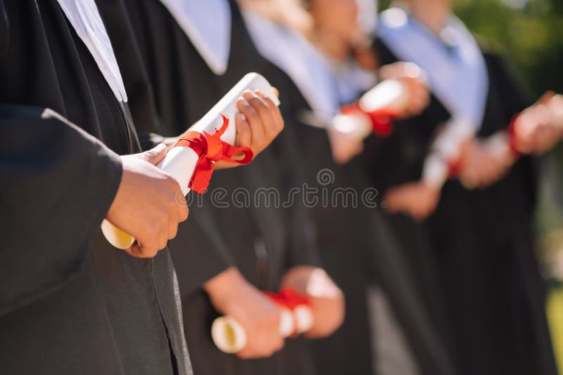 Graduates Holding Their Diplomas in a Roll. Stock Photo - Image of ...