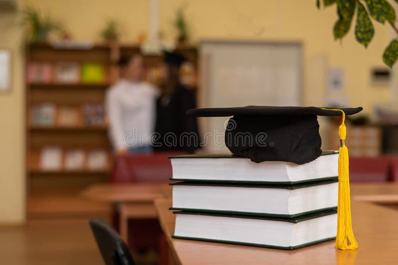 Graduation Cap on a Stack of Books in the Library. Stock Image - Image ...