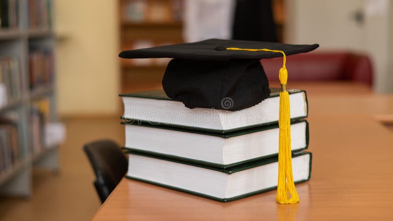 Graduation Cap on a Stack of Books in the Library. Stock Photo - Image ...